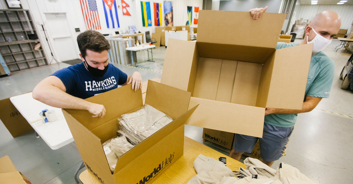 Box it up: Staff members help sort and pack thousands of clothes ...